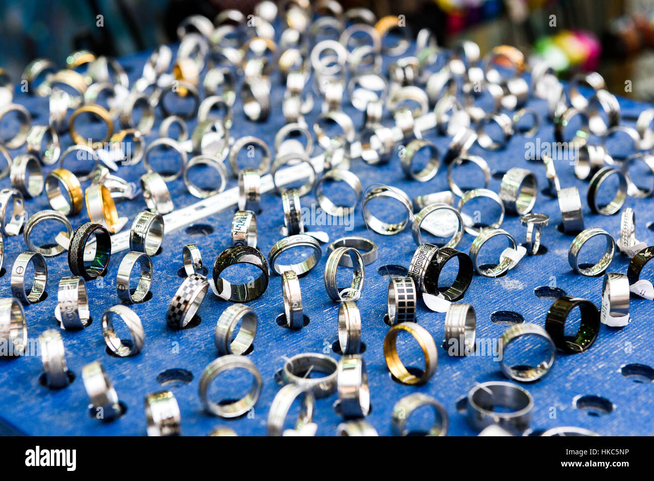 Display with different designs of handmade silver rings on blue stand ...
