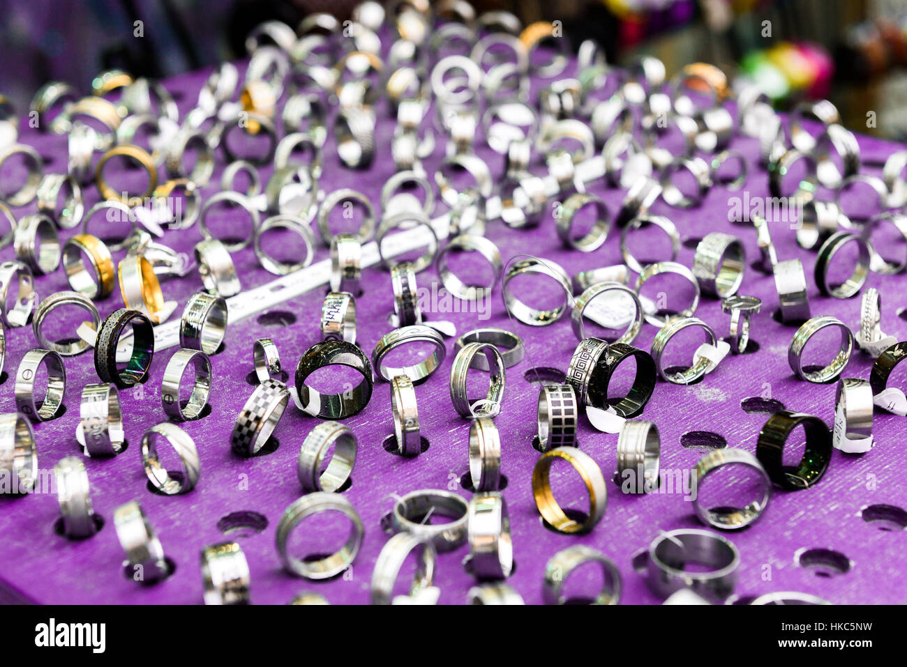Display with different designs of handmade silver rings on pink stand ...