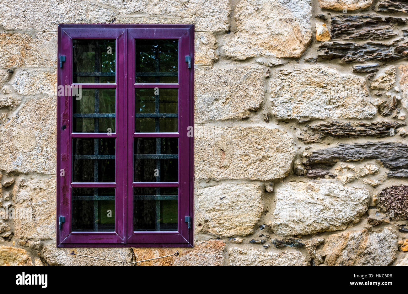 Purple window on medieval castle made of stone and rocks. Architectural ...