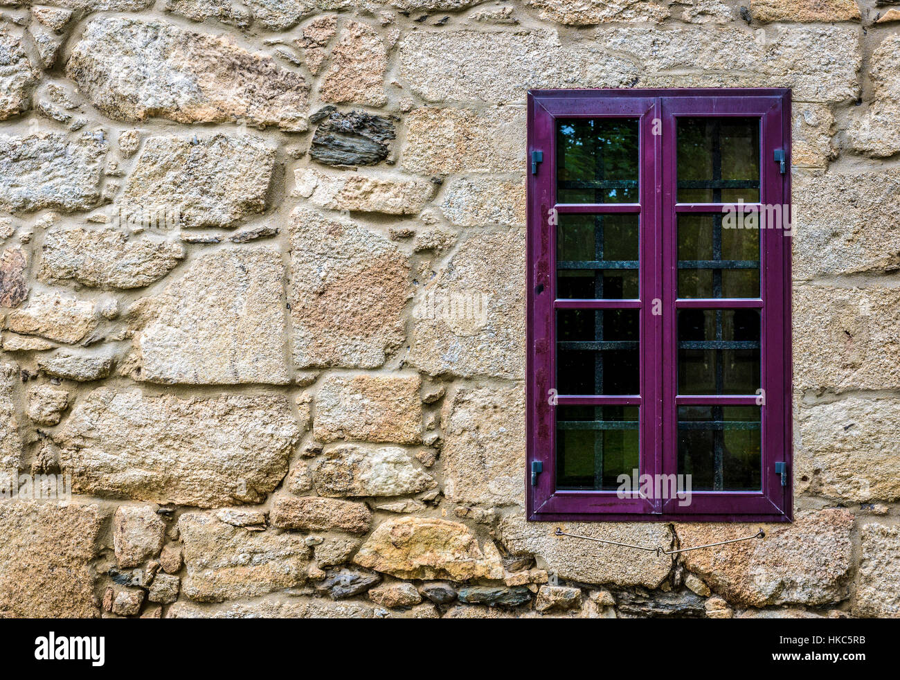 Purple window on medieval castle made of stone and rocks. Architectural ...