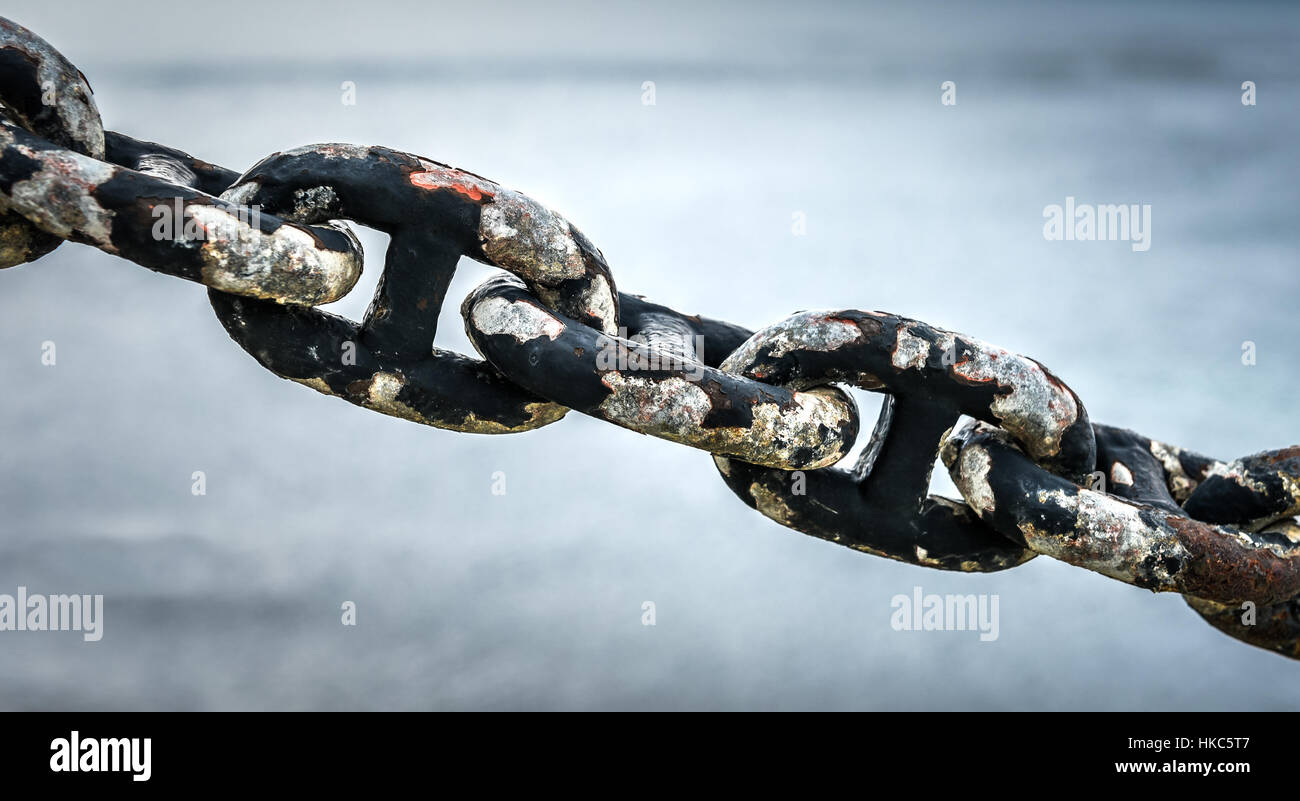 Old rusty anchor iron ship chain in sea port. Old fence made of ...