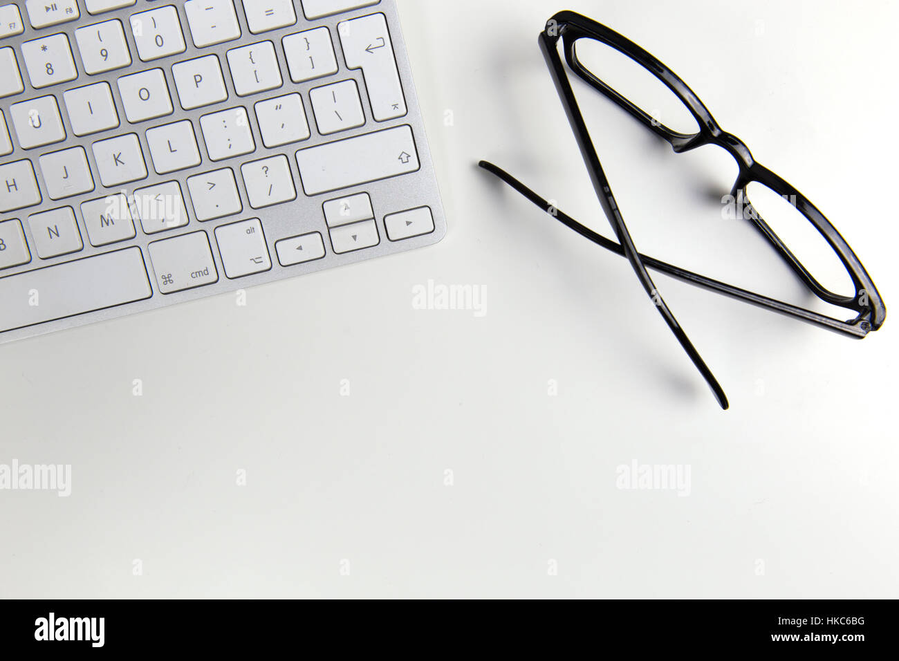 Glasses and computer keyboard on office desk Stock Photo - Alamy