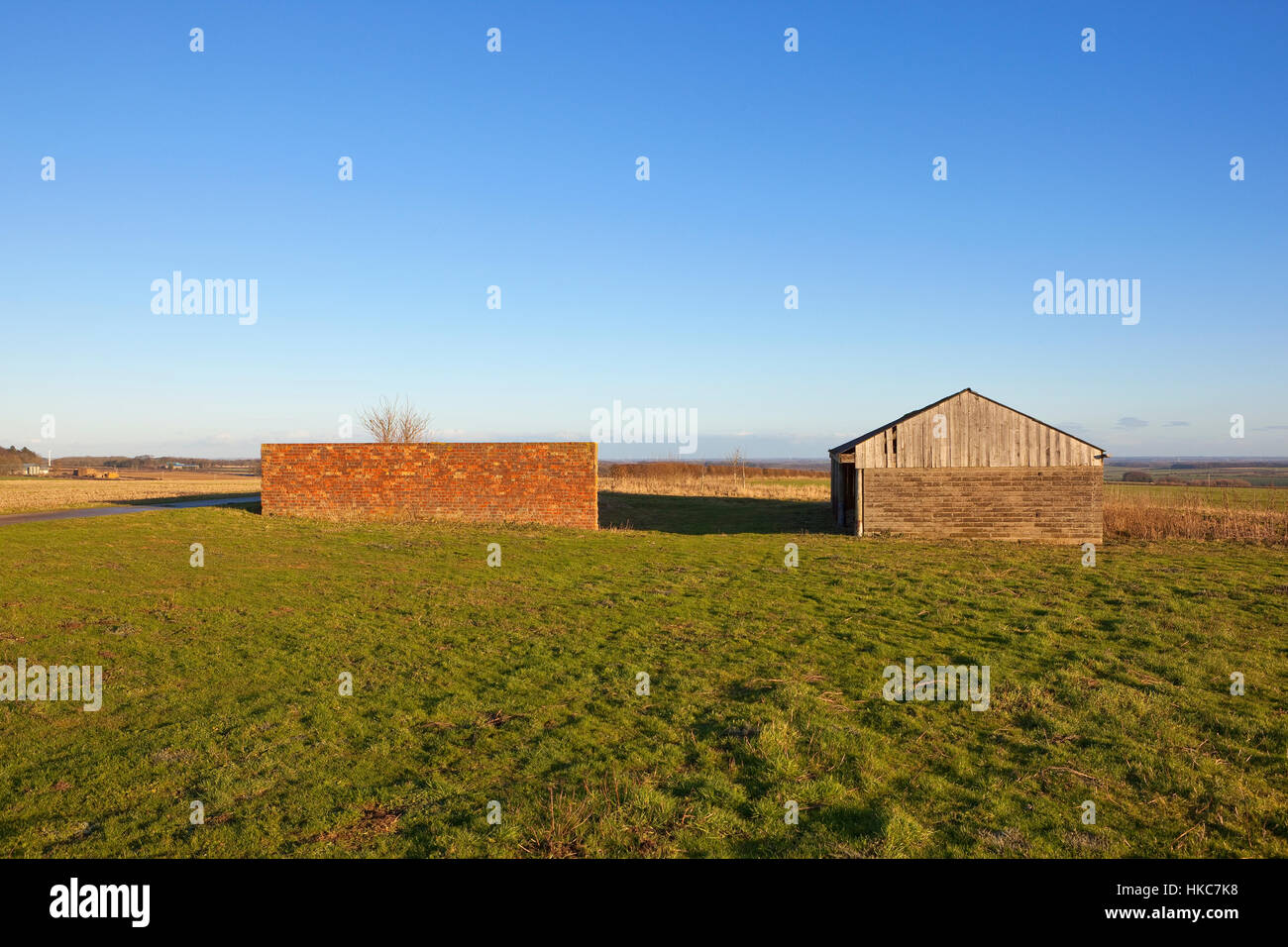 a stone farm building with a brick wall near a bridleway with views of ...
