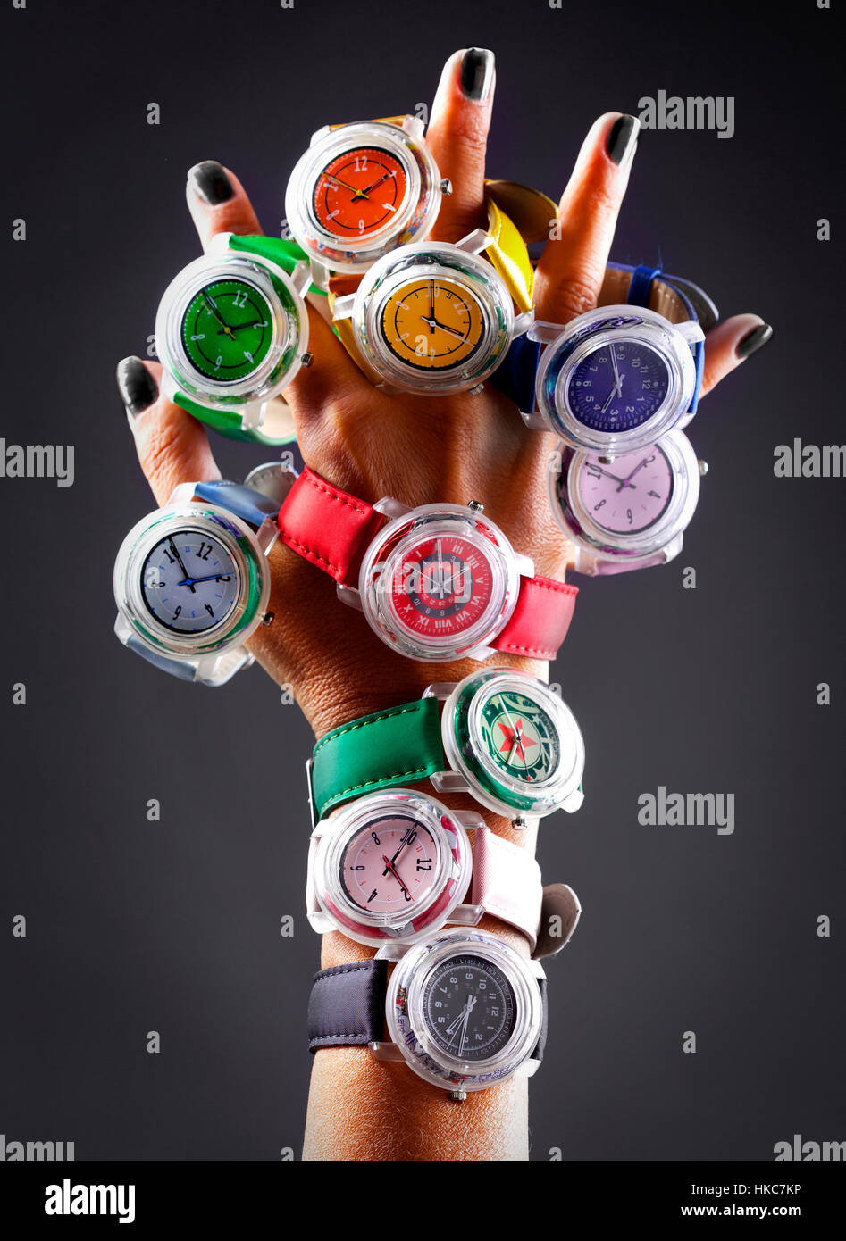 One hand teaches several similar watches on different colours Stock ...