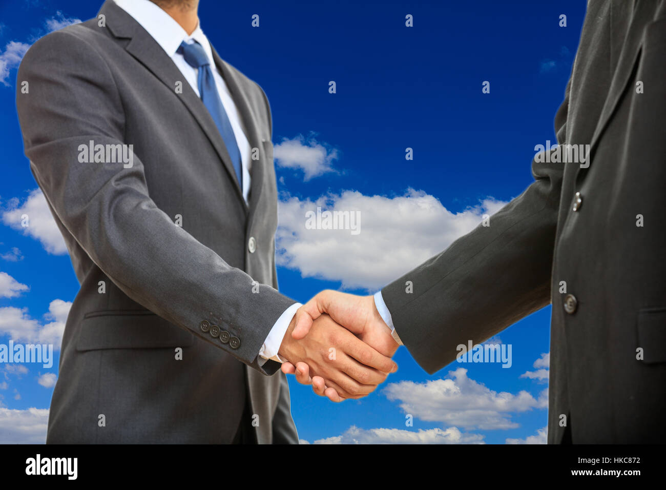 Formal handshake on blue sky background Stock Photo - Alamy