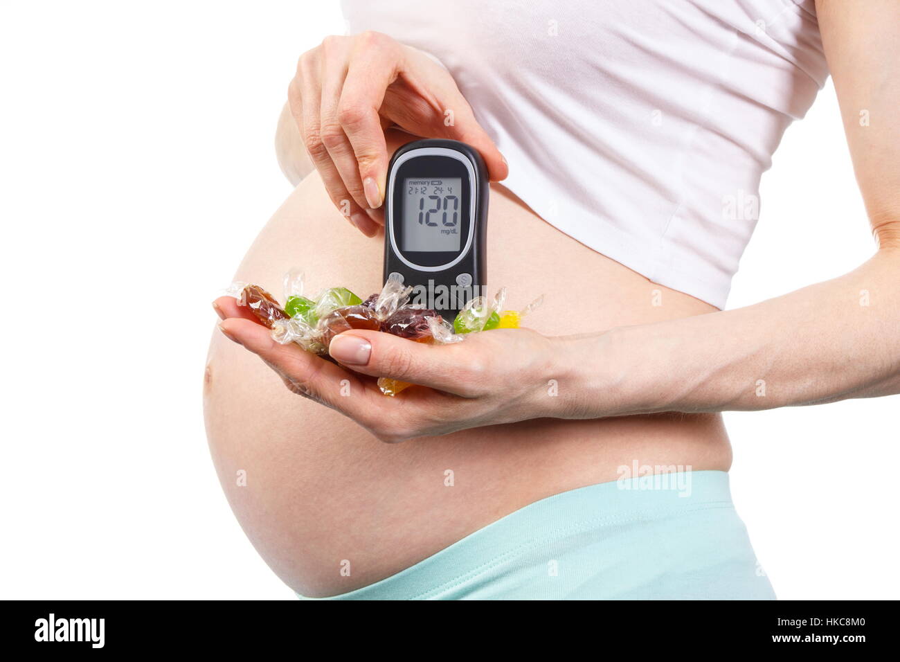 Pregnant woman holding colorful candies and glucose meter with result ...