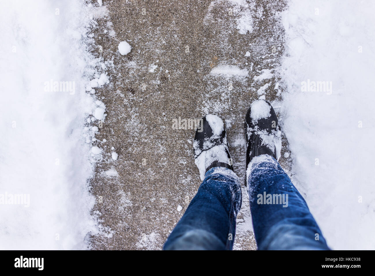 Sidewalk cleaned from winter snow with person's feet Stock Photo - Alamy