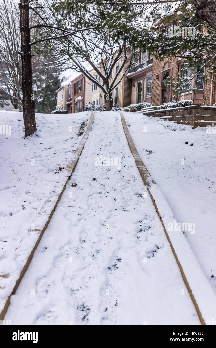 Sidewalk covered in winter snow on hill incline in neighborhood Stock ...