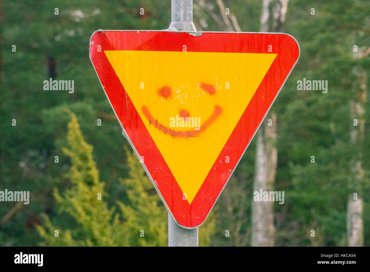 Smiley on a sign for Give priority to traffic on the main road ahead ...