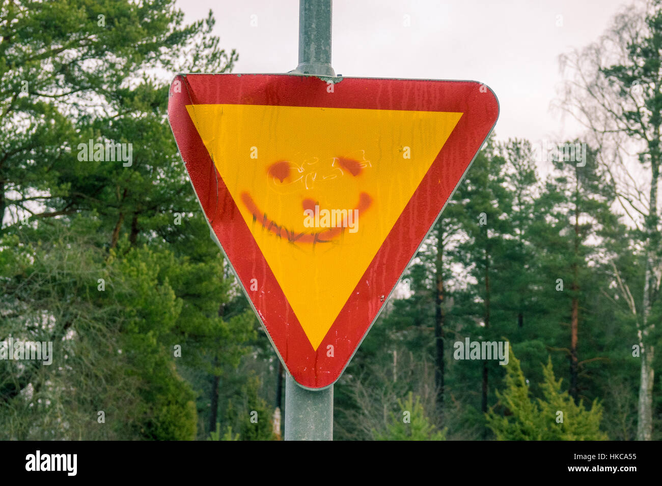 Smiley on a sign for Give priority to traffic on the main road ahead ...