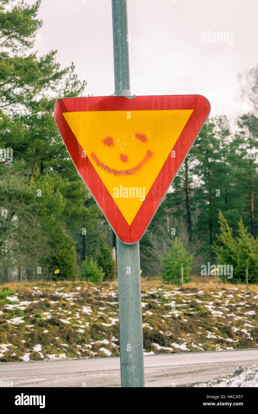 Smiley on a sign for Give priority to traffic on the main road ahead ...