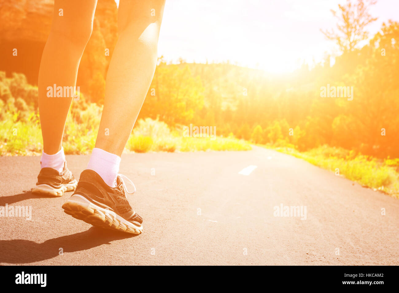 Legs in sport shoes on road at sunrise closeup Stock Photo - Alamy