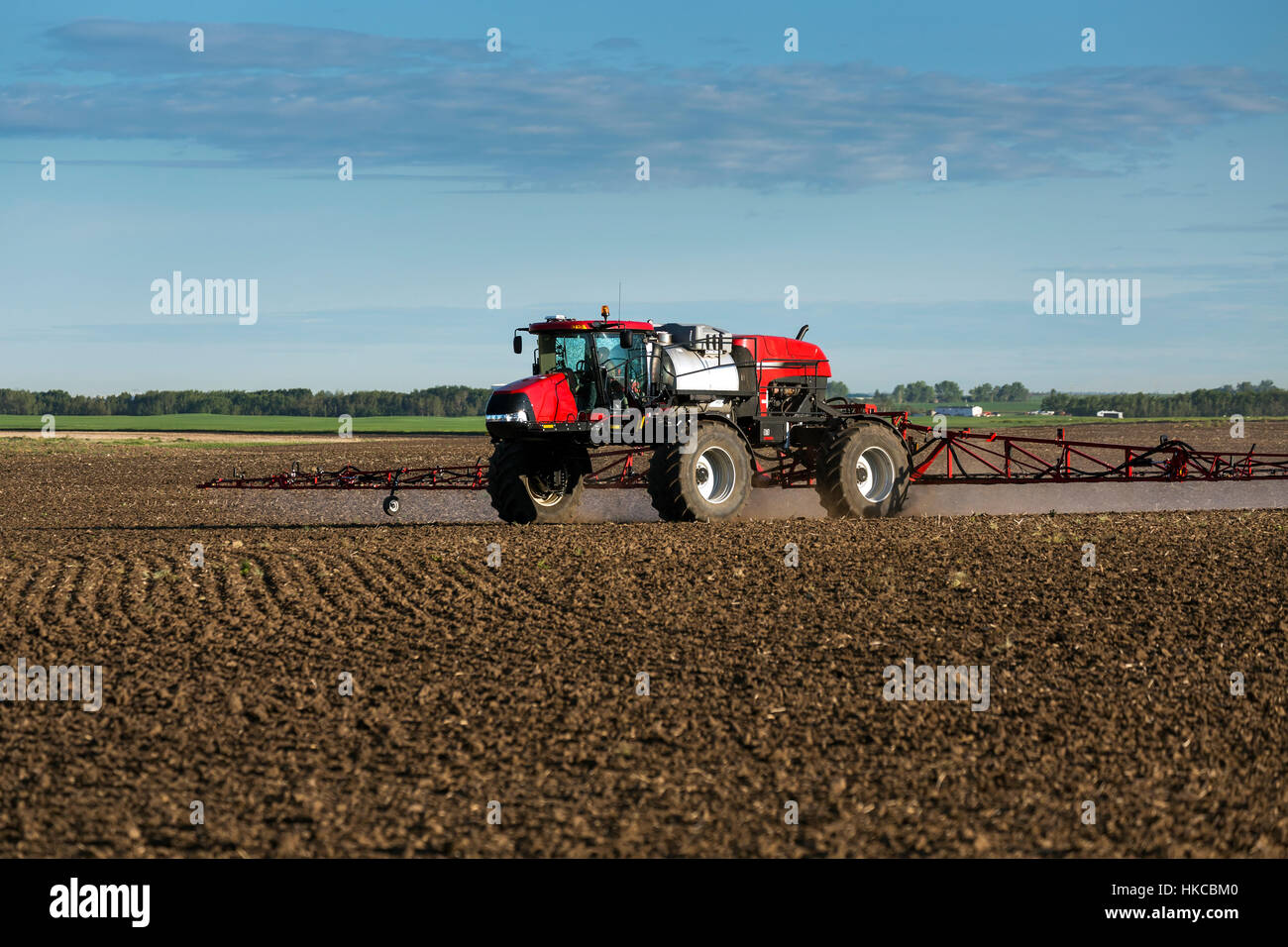 Crop sprayer in clean soil field with blue sky and clouds, East of ...