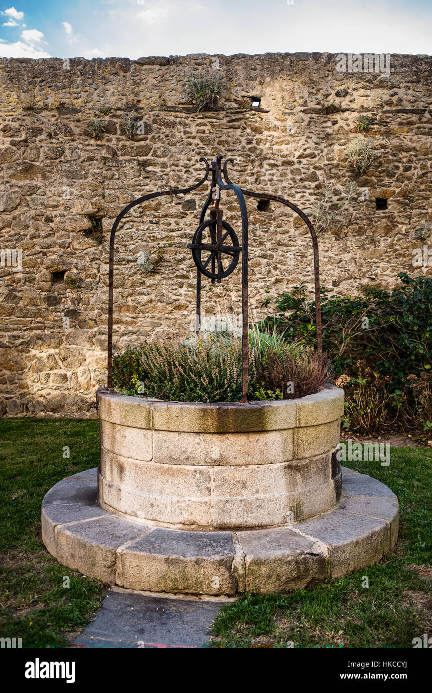 Decorative stone well with flowers and wheel in Saint-Malo, France ...