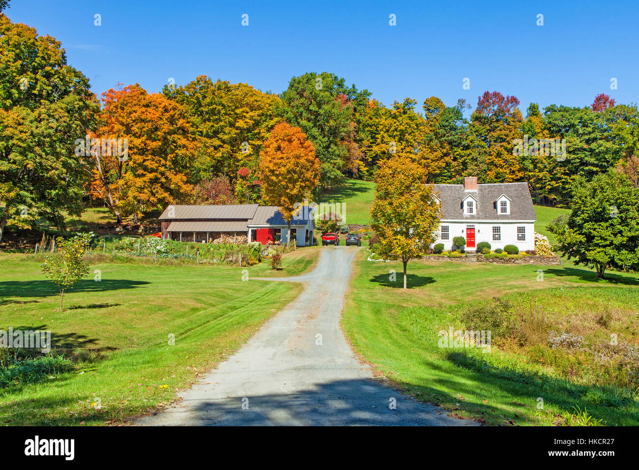 A fully restored Cape-style home with dormers set among coloruful Maple ...
