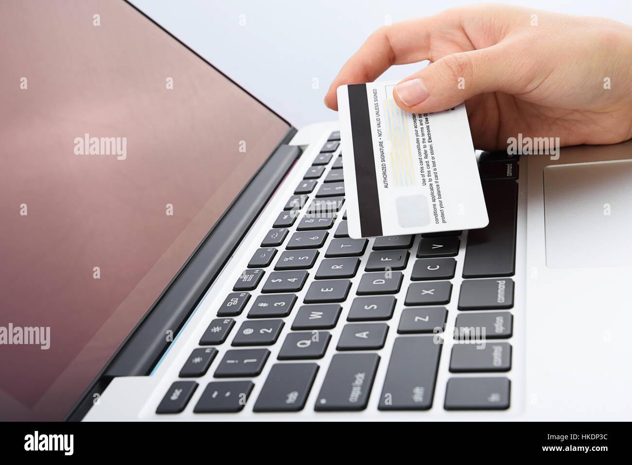 horizontal shot of Human next to laptop with credit card on white ...