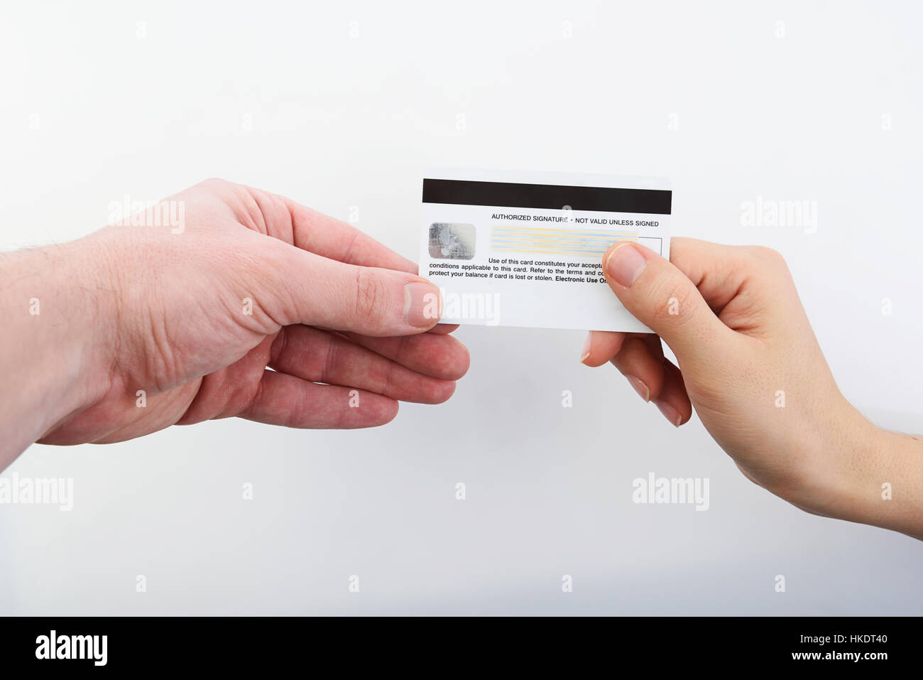 One hand gives credit card to other hand on white background Stock ...