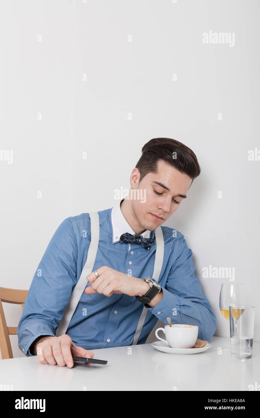 Man sitting with a glass of wine and a cup of coffee and looking ...