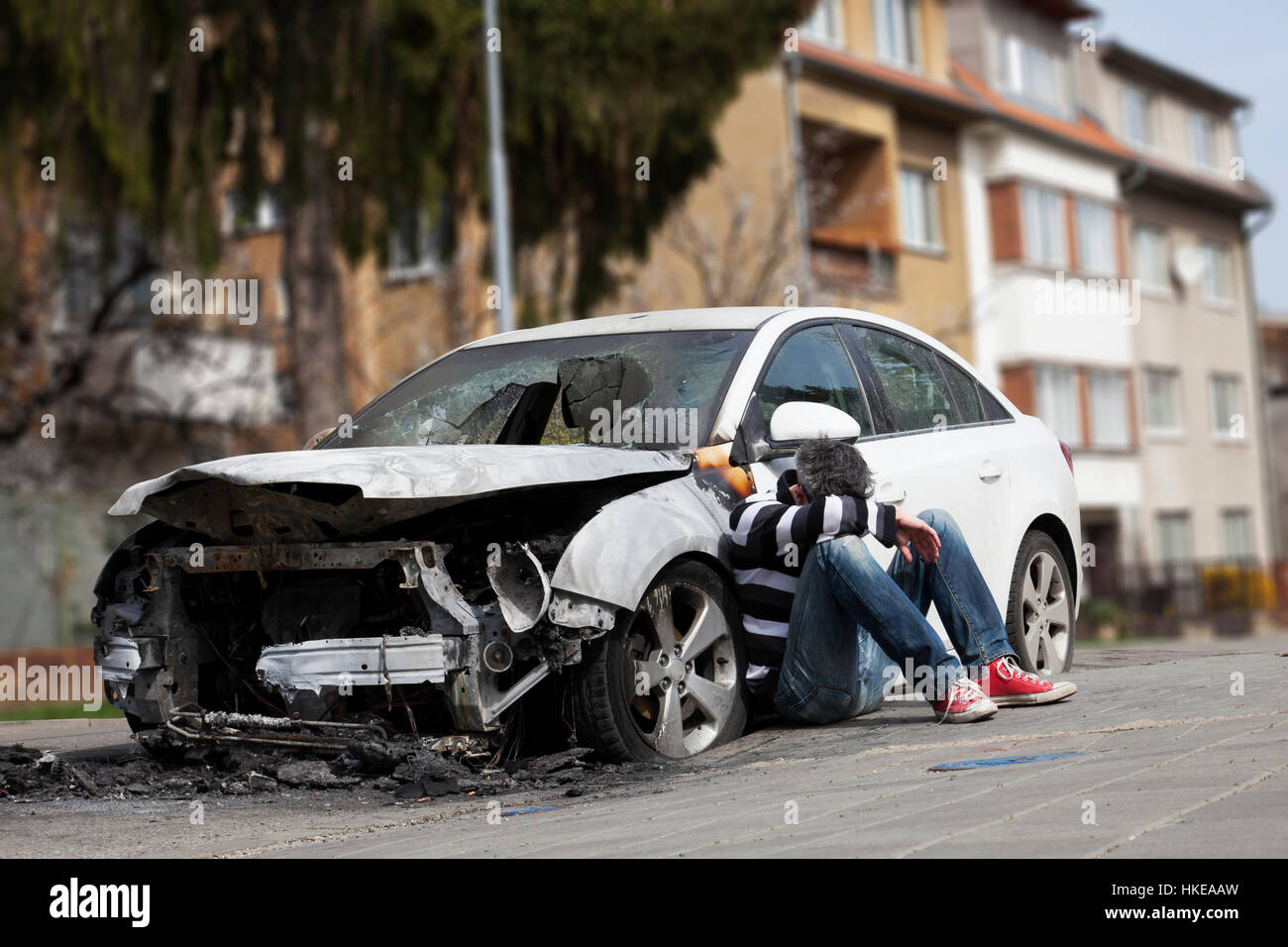 crying man sitting next to his brand new car burned by vandals downtown ... crying man sitting next to his brand new car burned by vandals downtown ...
