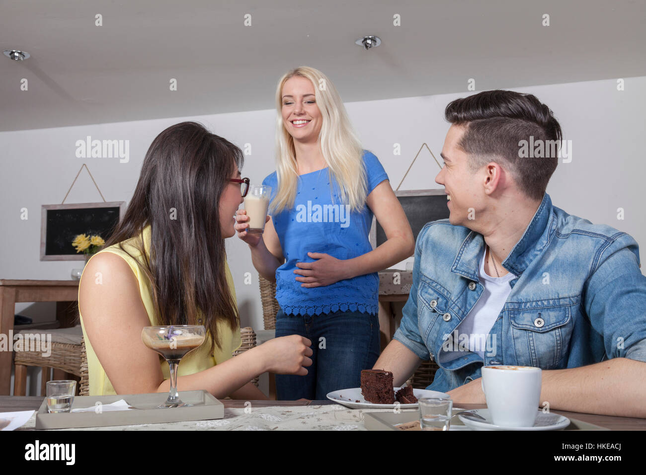 Three friends in cafeteria environment Stock Photo - Alamy