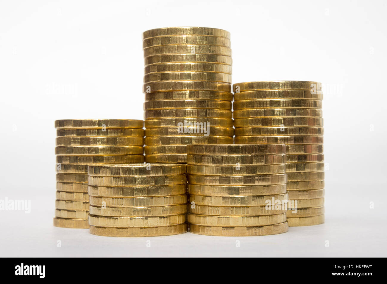 Five stacks of coins of different height on a white background Stock ...