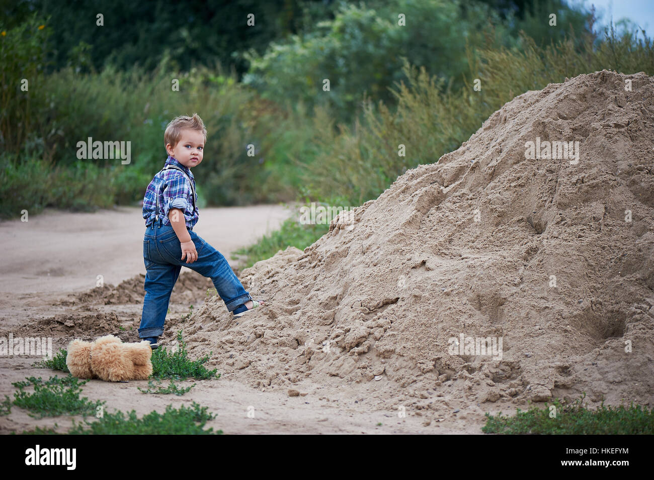 Cute little boy standing near a big pile . Memories of childhood and ...