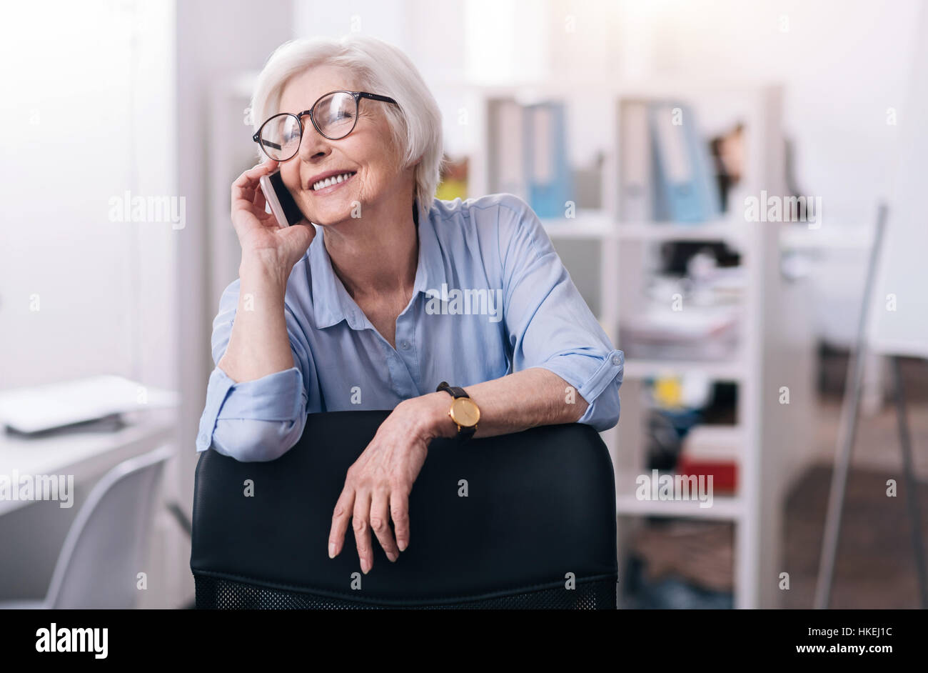 Smiling senior woman talking over the phone in the office Stock Photo ...
