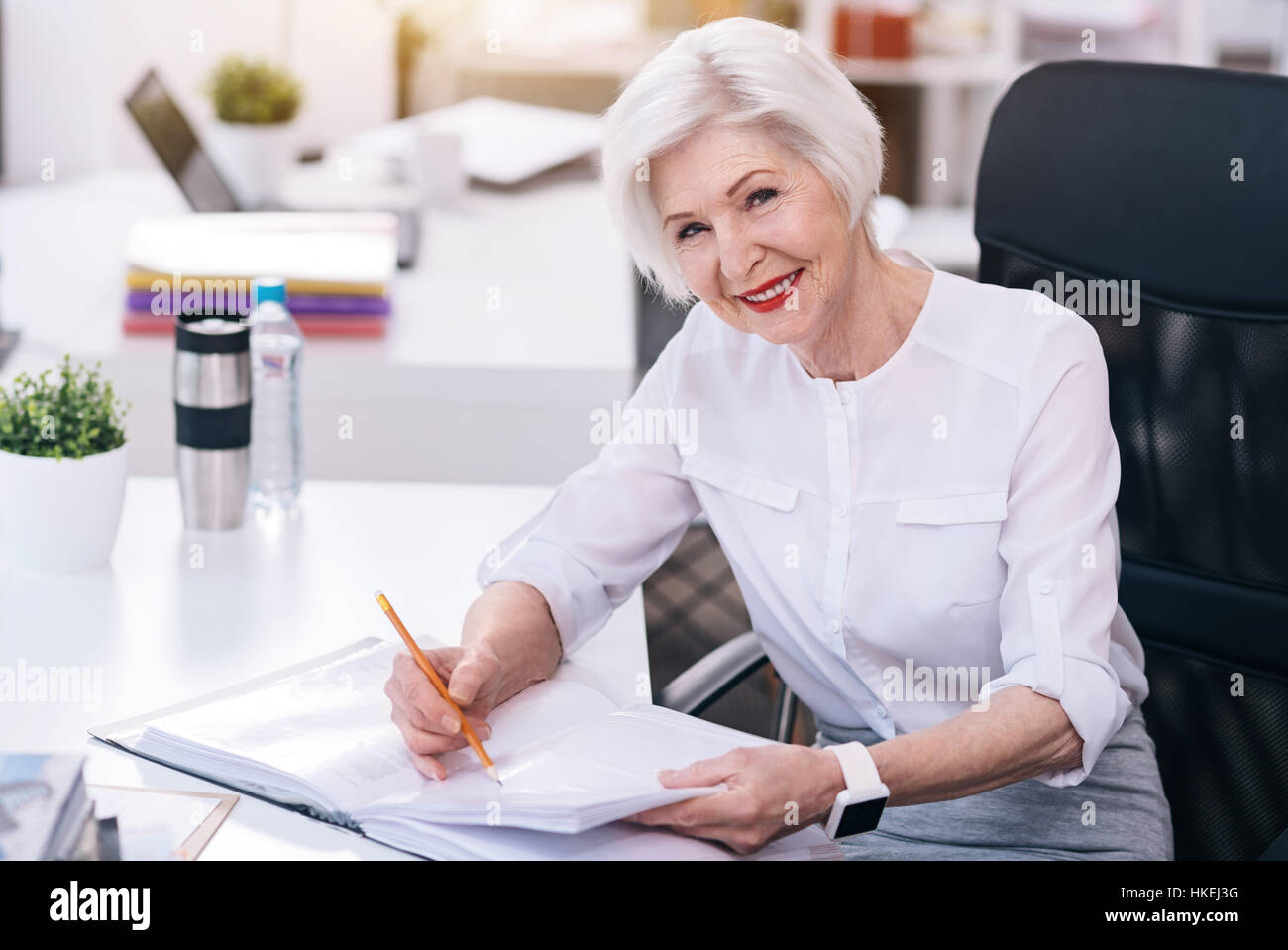 Smiling aged business lady performing her responsibilities in the ...