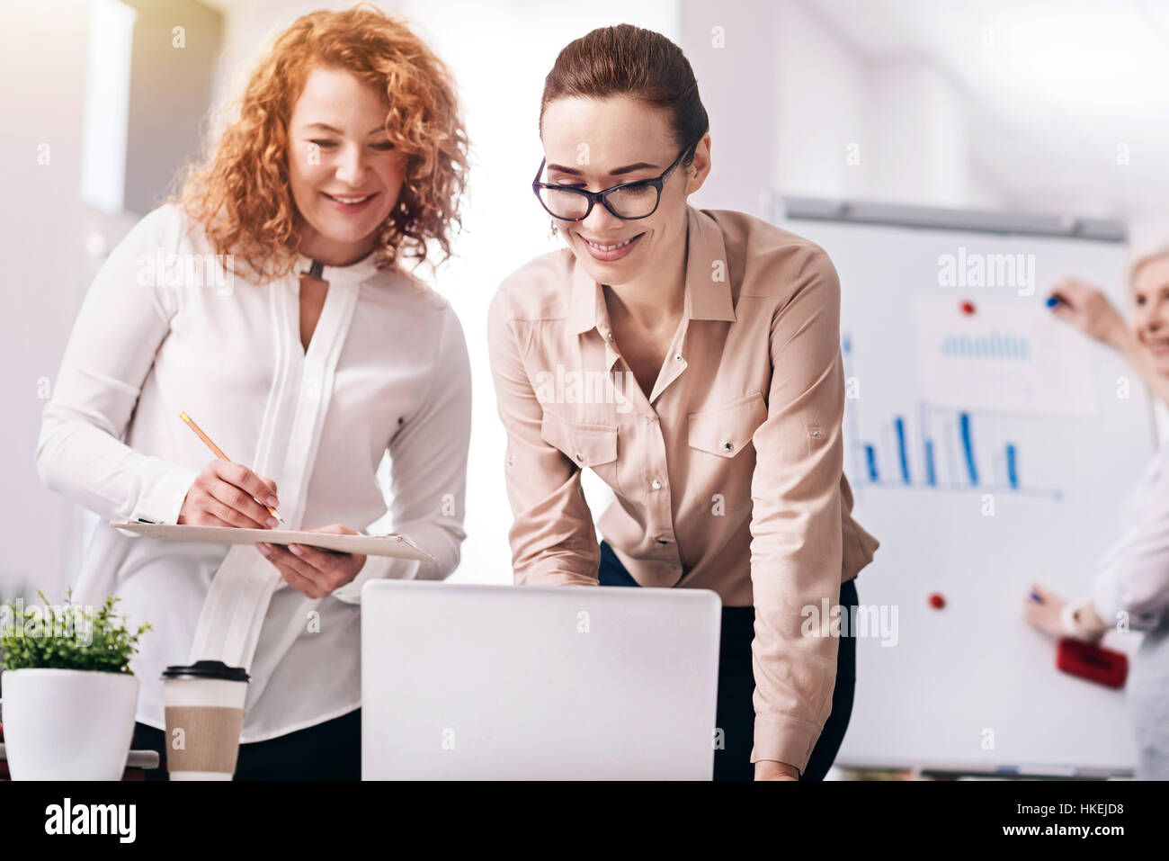 Delighted involved colleagues collaborating in the office Stock Photo ...