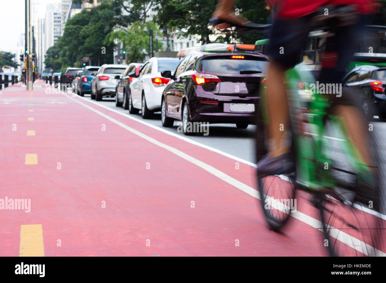 Cyclist passing bicycle lane and while a row of cars are stuckk in ...