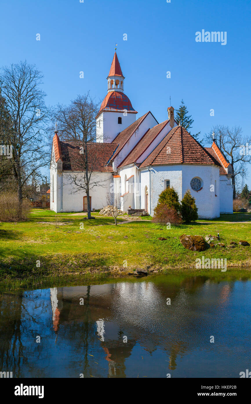 Traditional local Estonian Lutheran church. White stone and red tile ...