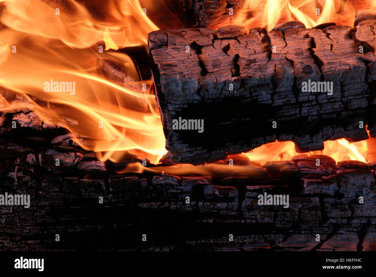 burning logs burned in the fire - background Stock Photo - Alamy