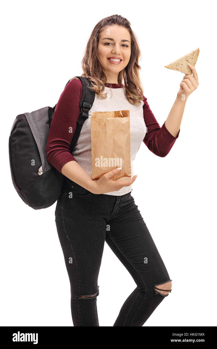 Happy female student holding a paper bag and a sandwich isolated on ...