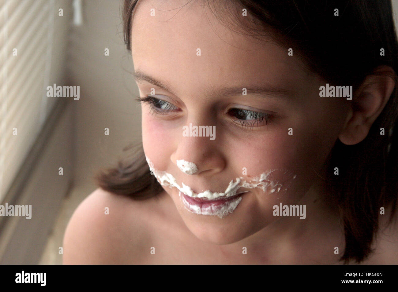 Young girl secretly eating a desert and getting all messy Stock Photo ...