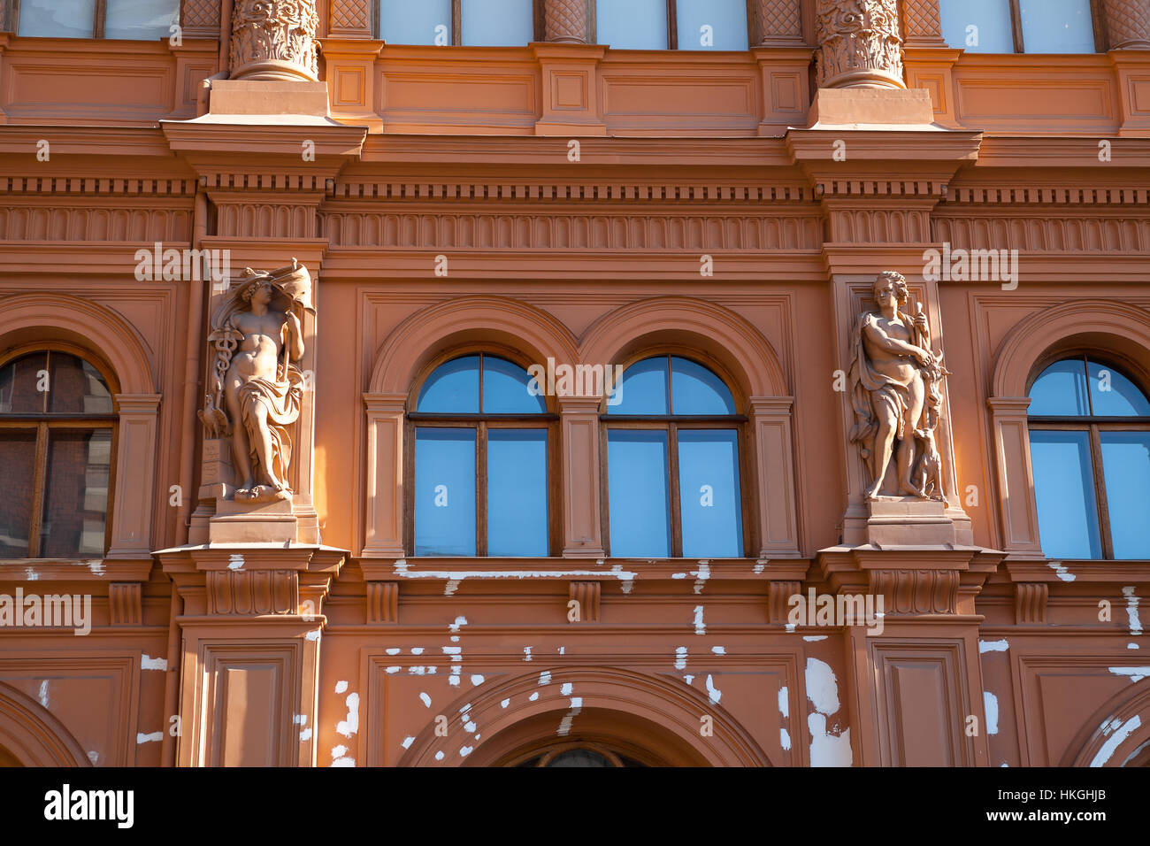 Classic style red building with statues on the facade. Details of ...
