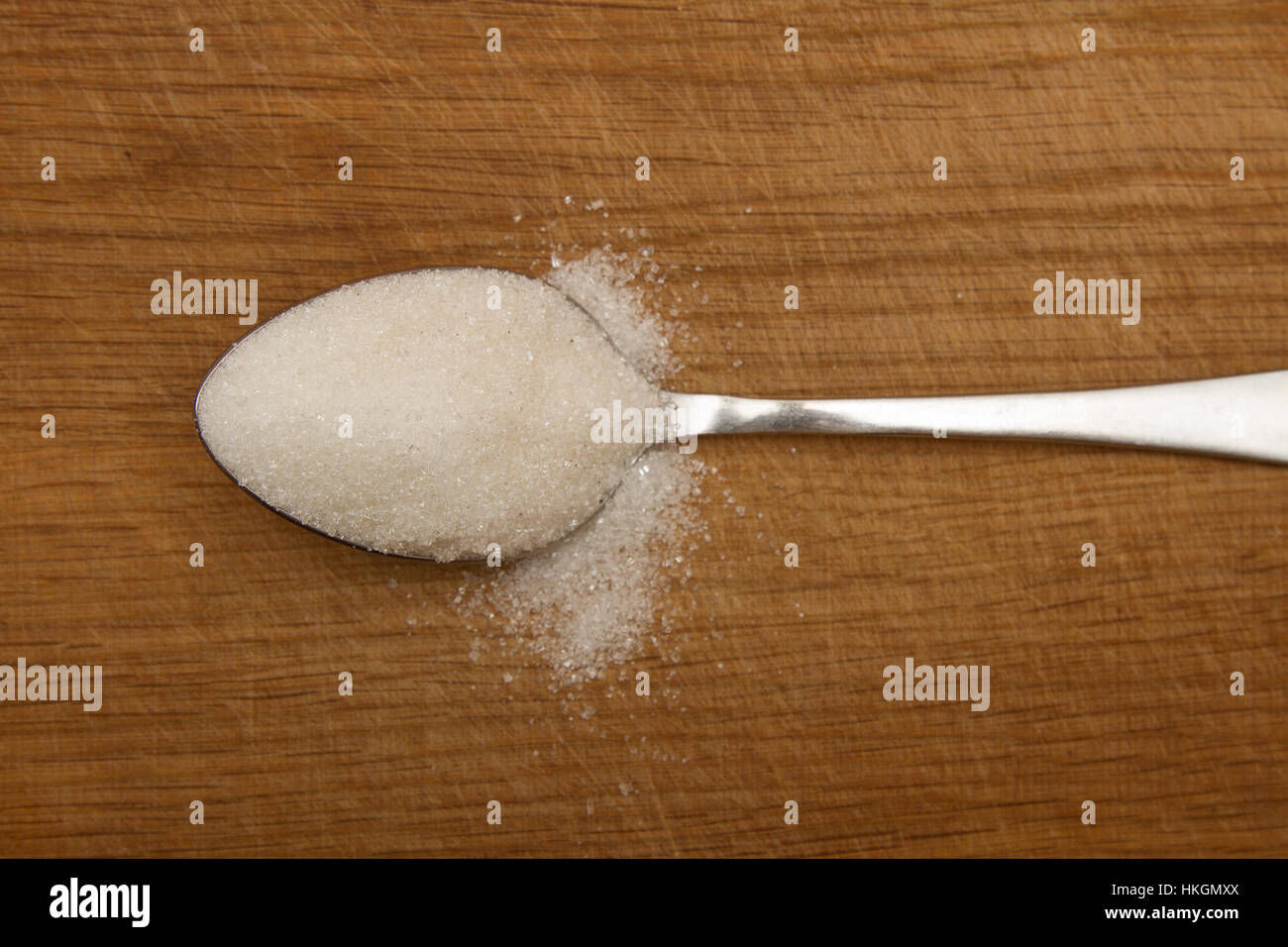 spoon of sugar on a wooden background Stock Photo - Alamy