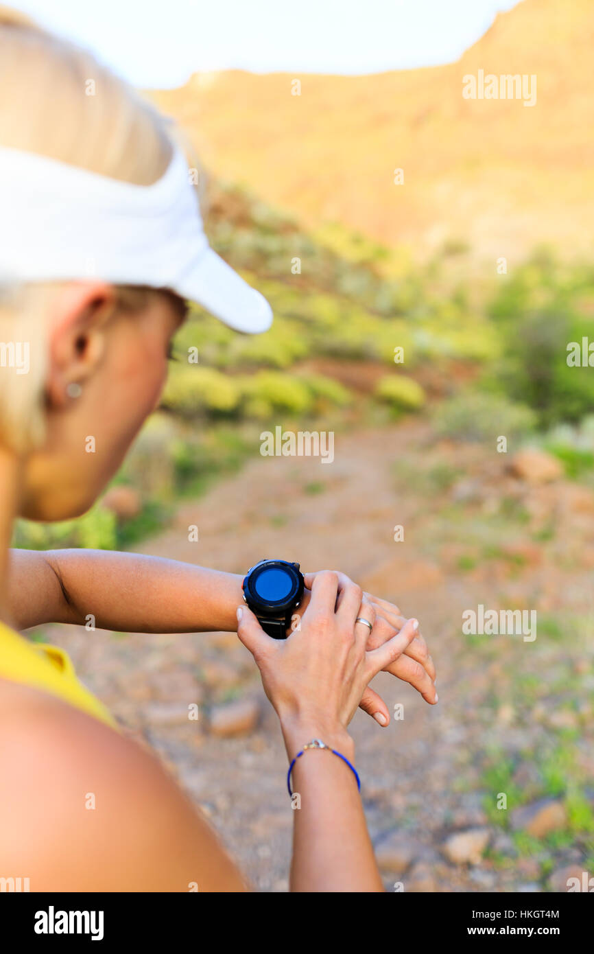 Woman runner checking the elevation on sports watch, smartwatch with ...