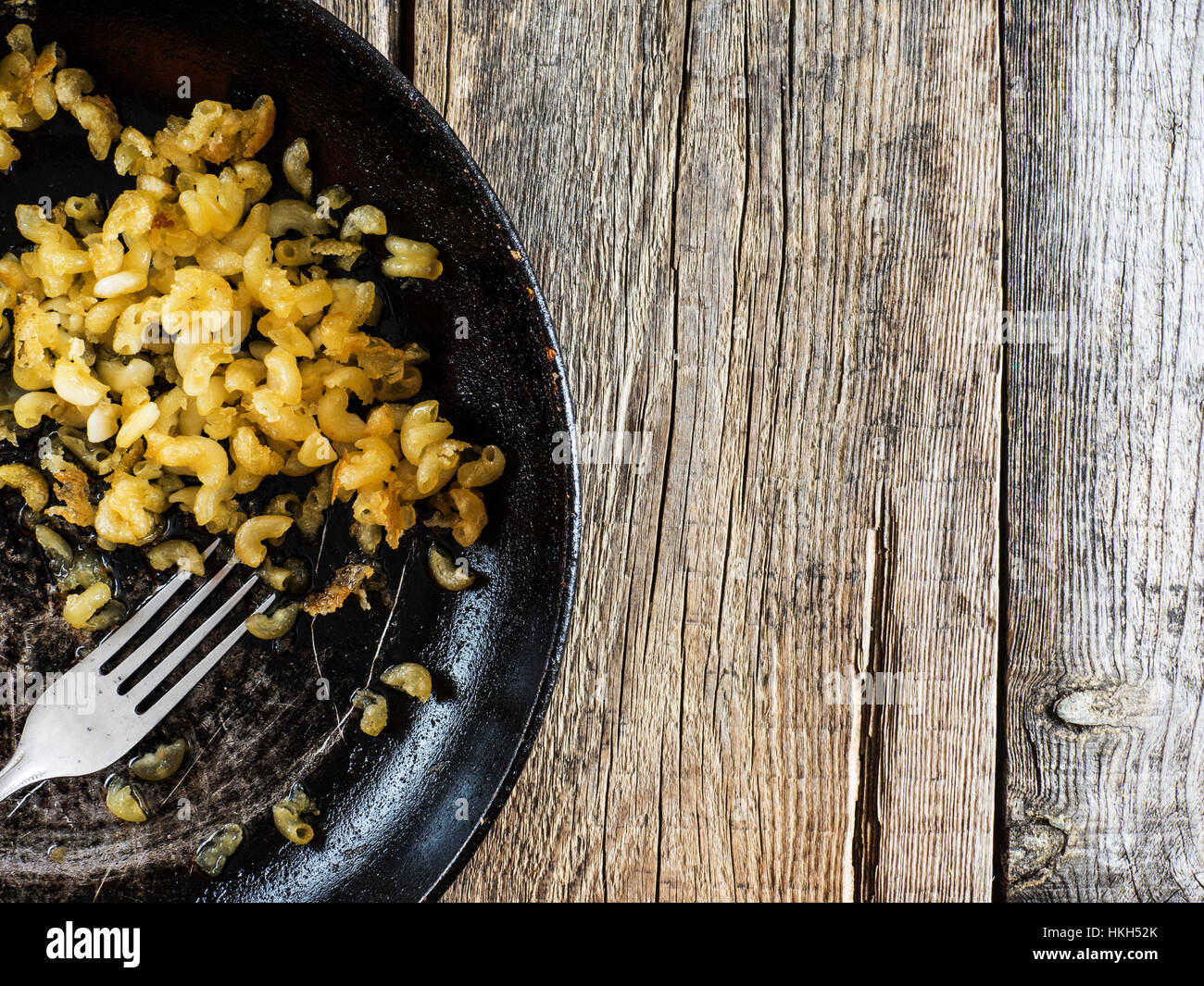 Spoiled food: dried pasta in a pan on old weathered wooden table Stock ...