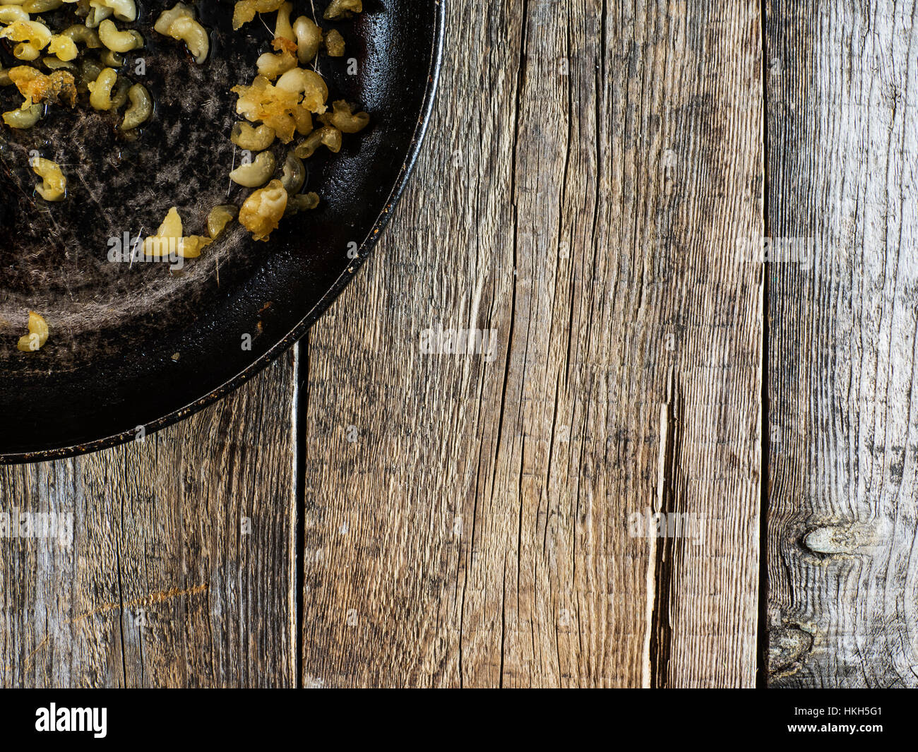 Spoiled food: dried pasta in a pan on old weathered wooden table Stock ...