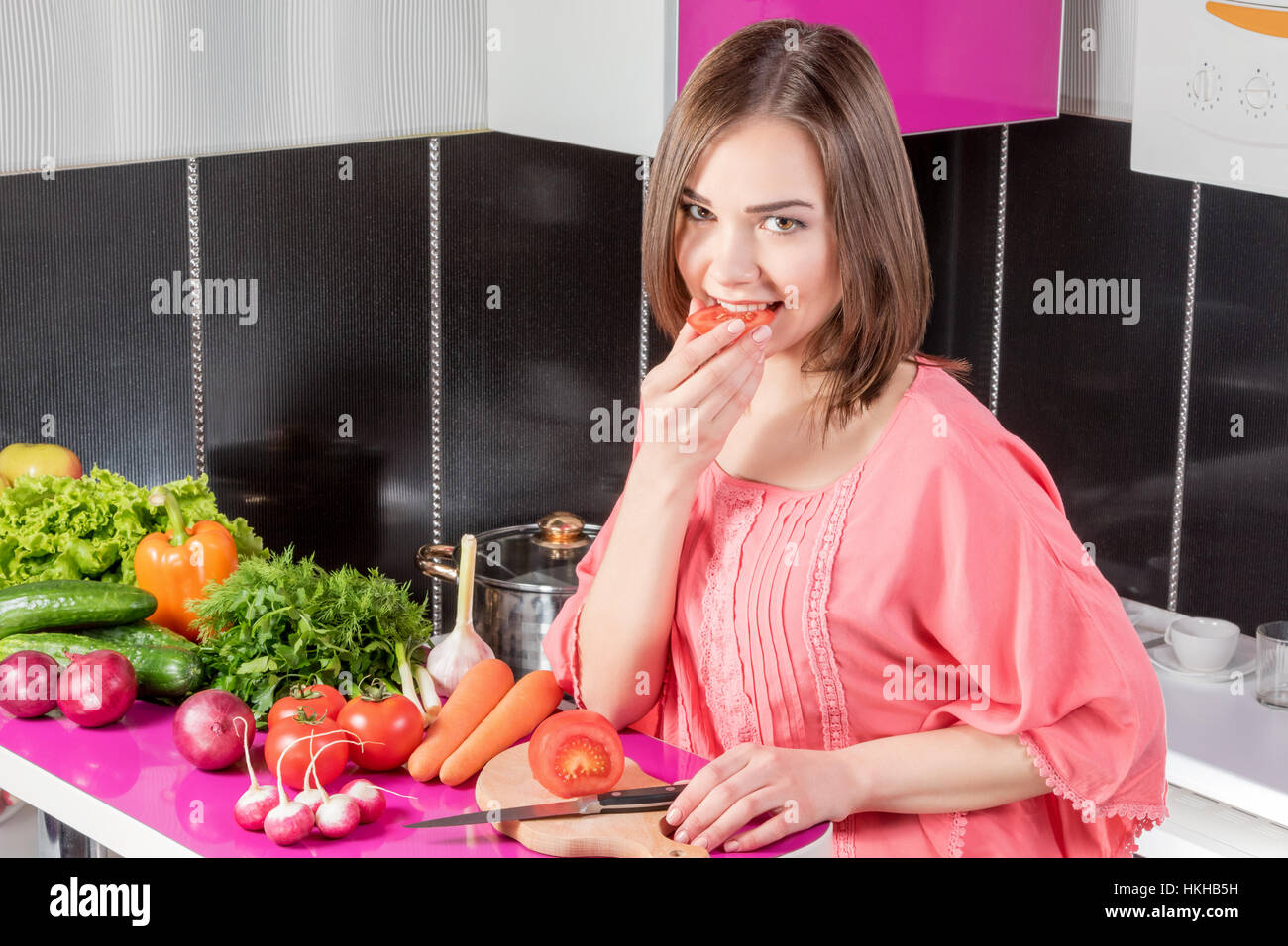 Woman eating tomato Stock Photo - Alamy