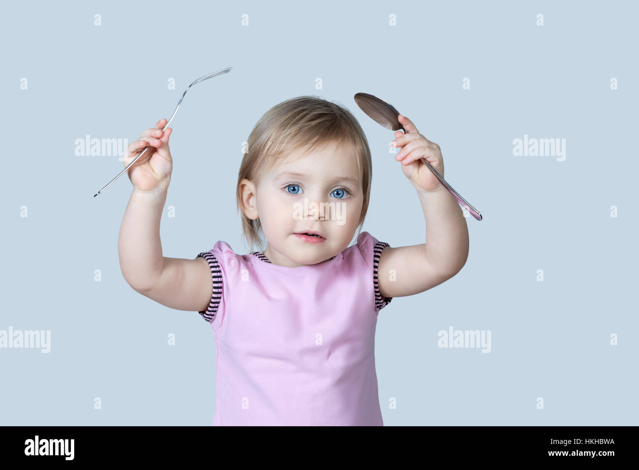 Little baby with a spoon and fork Stock Photo - Alamy
