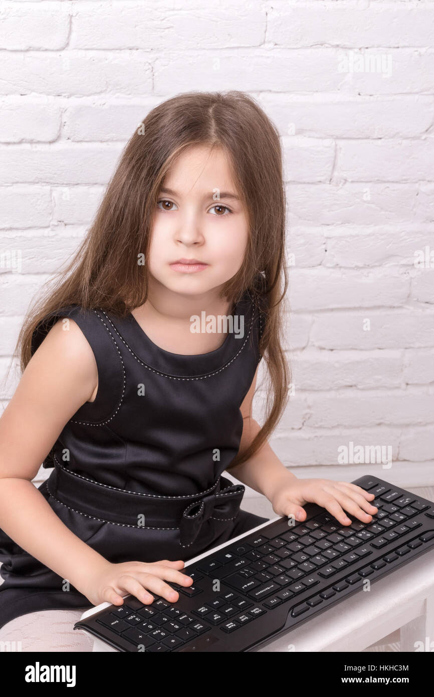 Girl sitting and working at the keyboard Stock Photo - Alamy