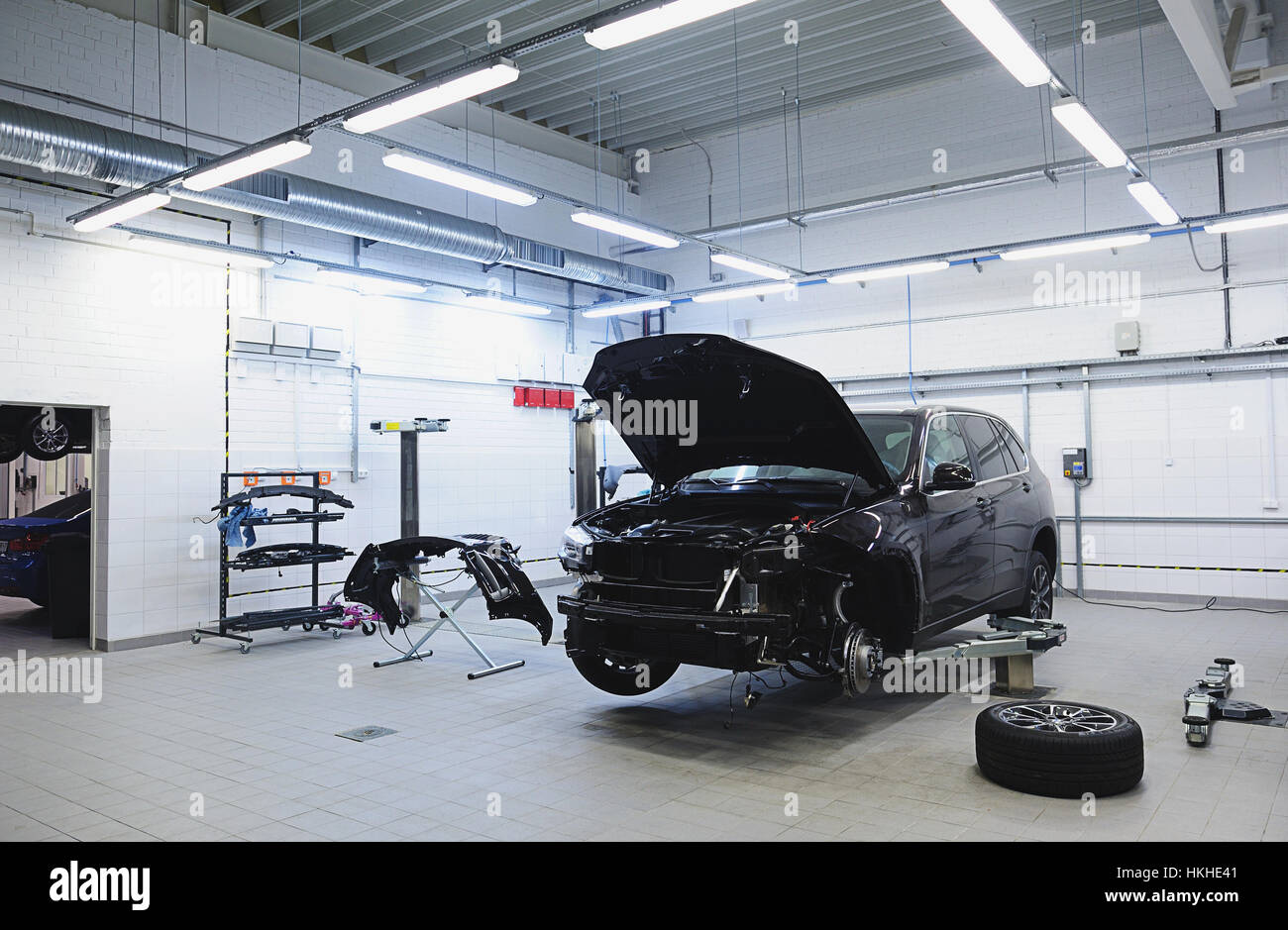 Car without bumper and wheel repairing in garage Stock Photo - Alamy