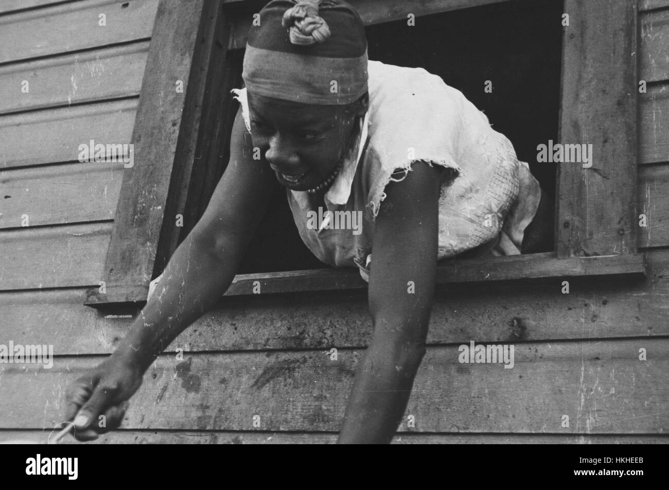 A photograph of a woman reaching out of a window to receive a relief ...