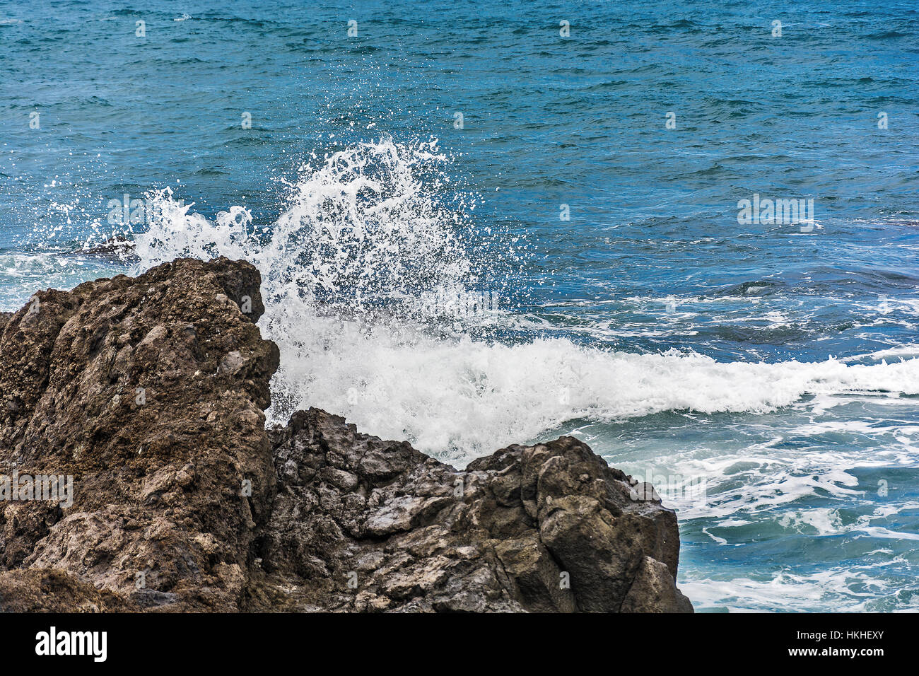 Splashes of water breaking on rocks Stock Photo - Alamy
