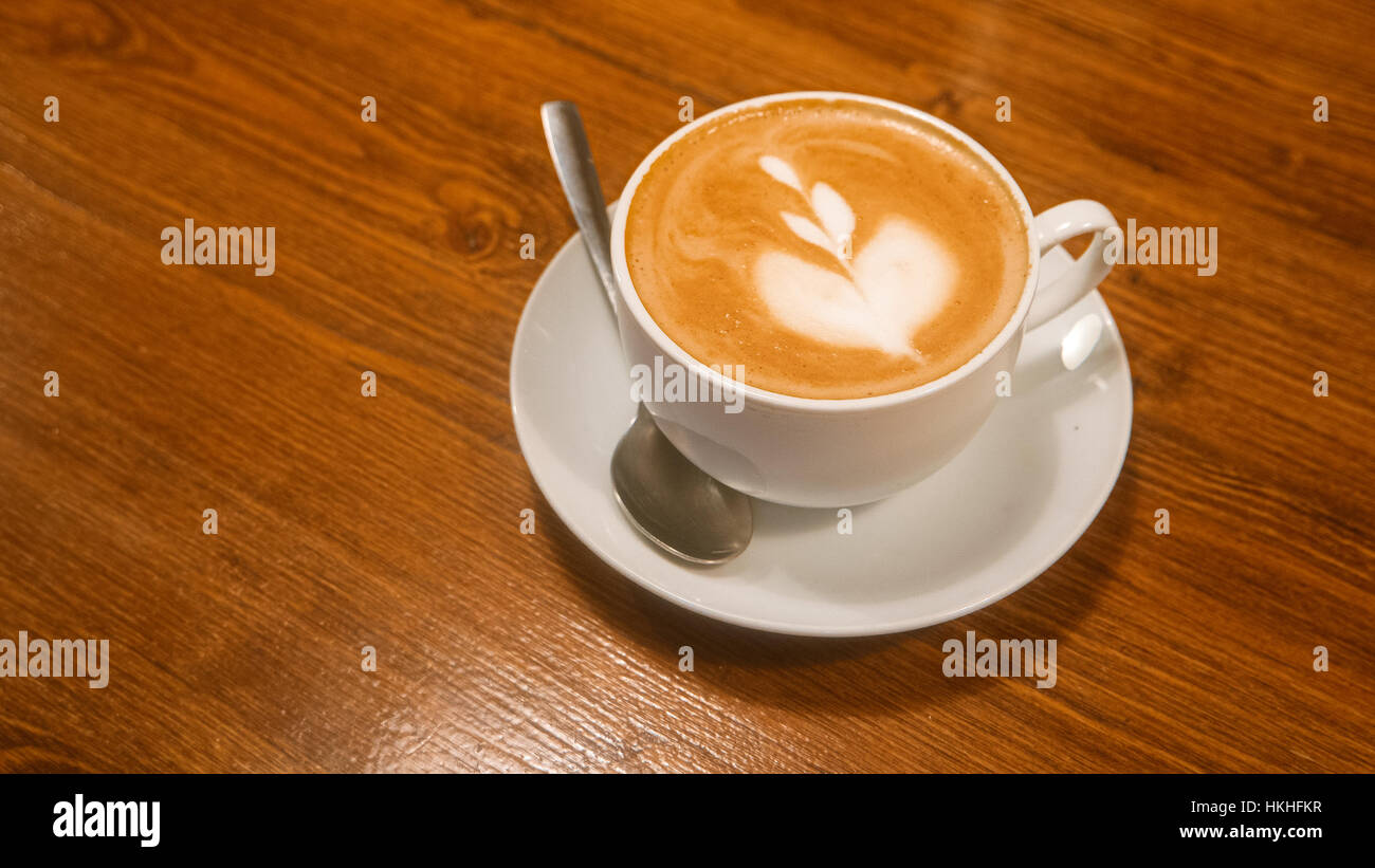 Cup of cappuccino coffee on brown wooden table. Above view Stock Photo ...