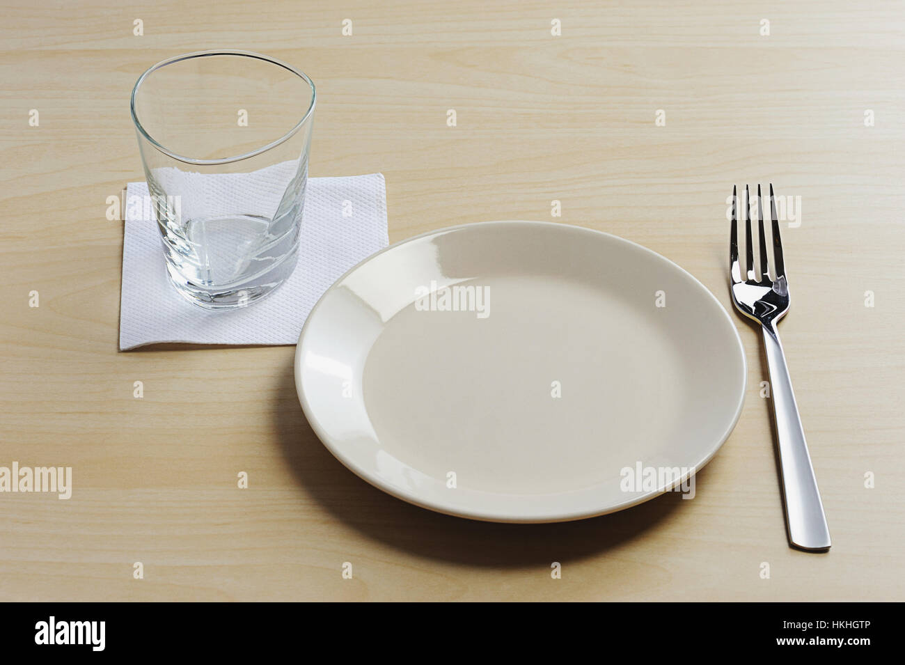empty plate on wood table with glass and fork Stock Photo - Alamy