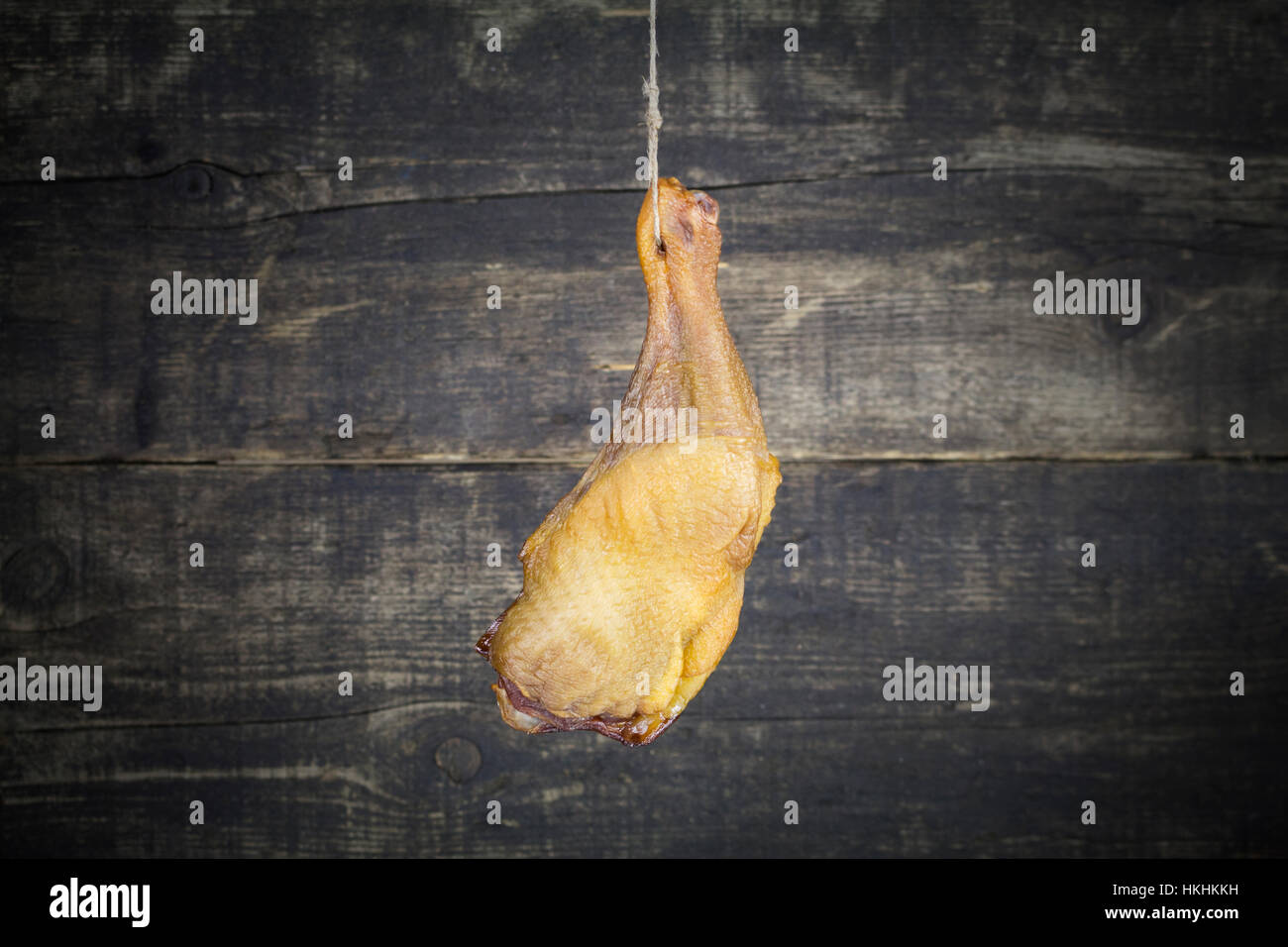 Smoked Chicken Leg Hanging on the Rope Against Wooden Background Stock ...