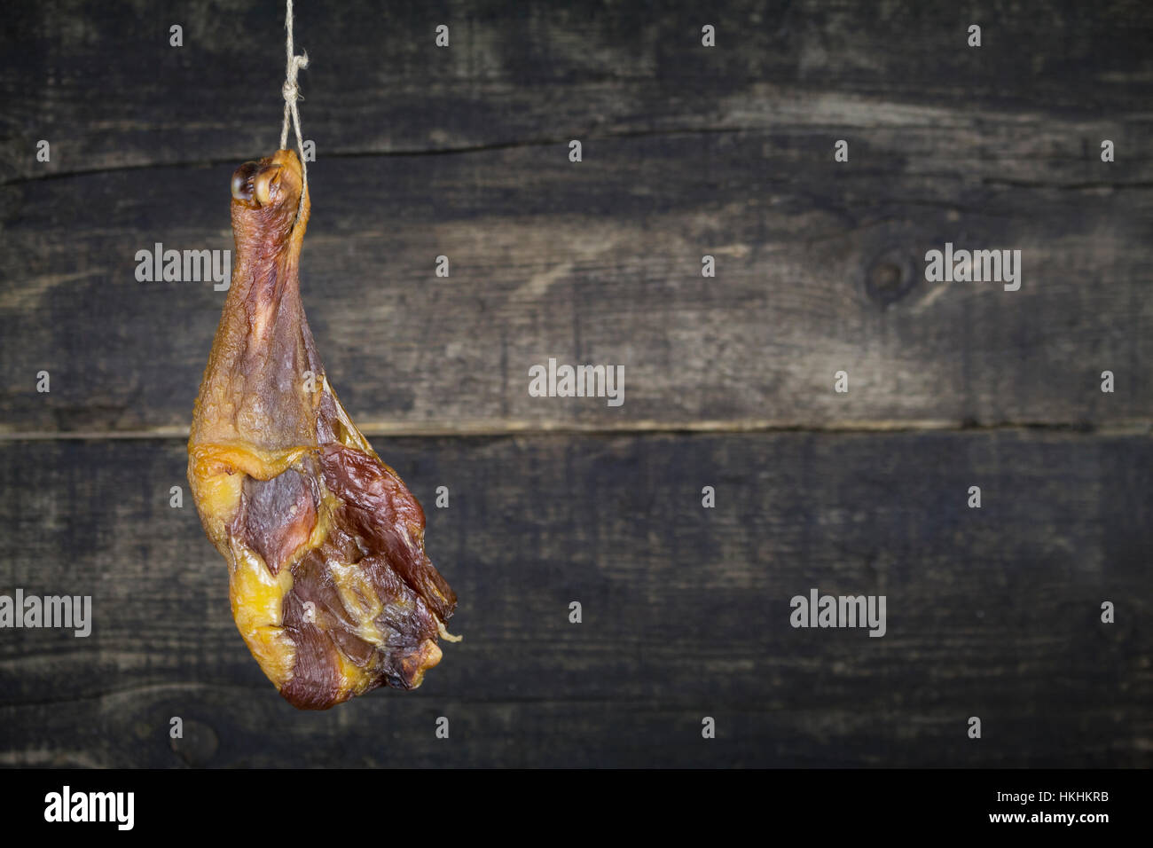 Smoked Chicken Leg Hanging on the Rope Against Wooden Background Stock ...