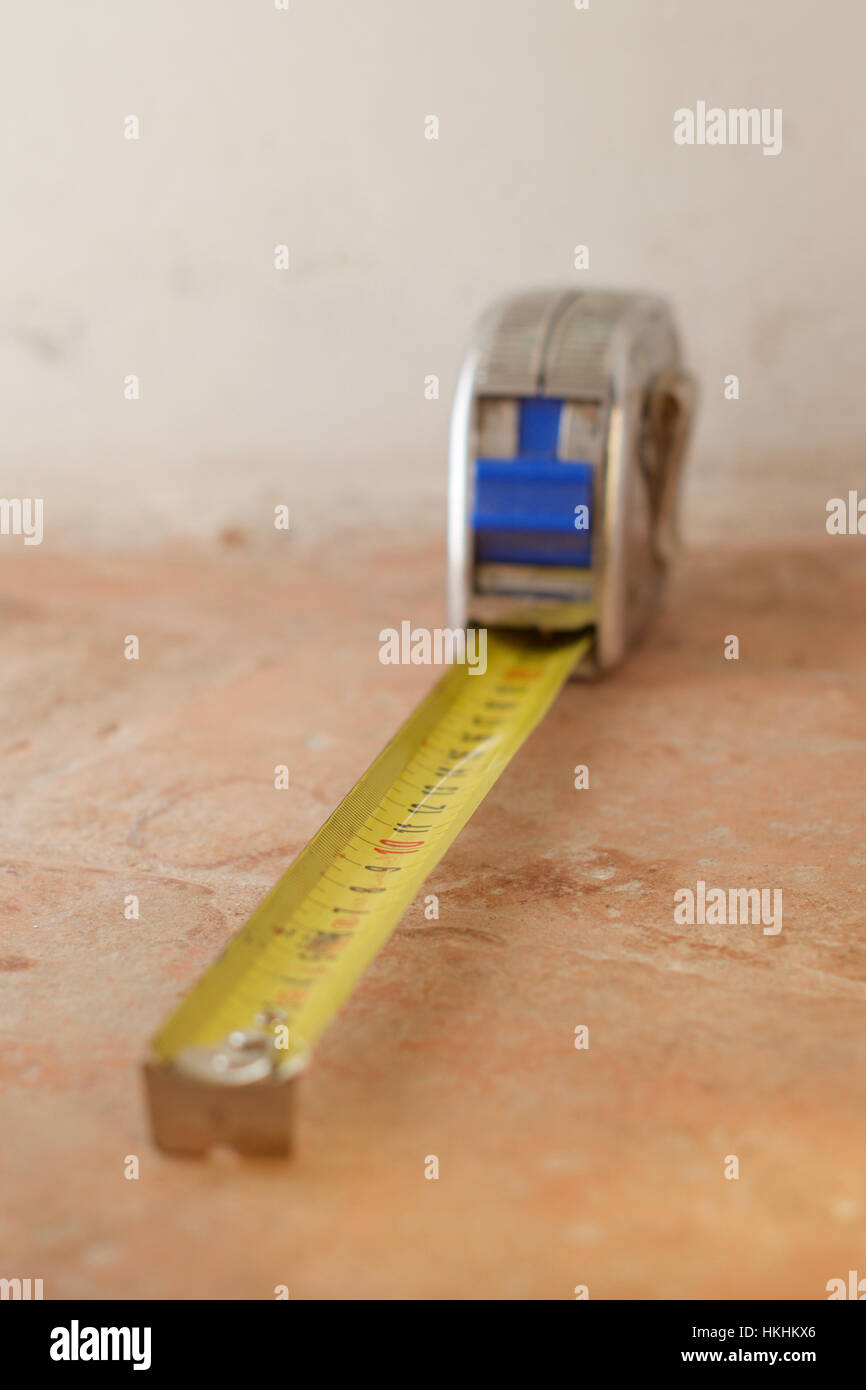 A metal tape measure with the tape extended with the focus on the ...